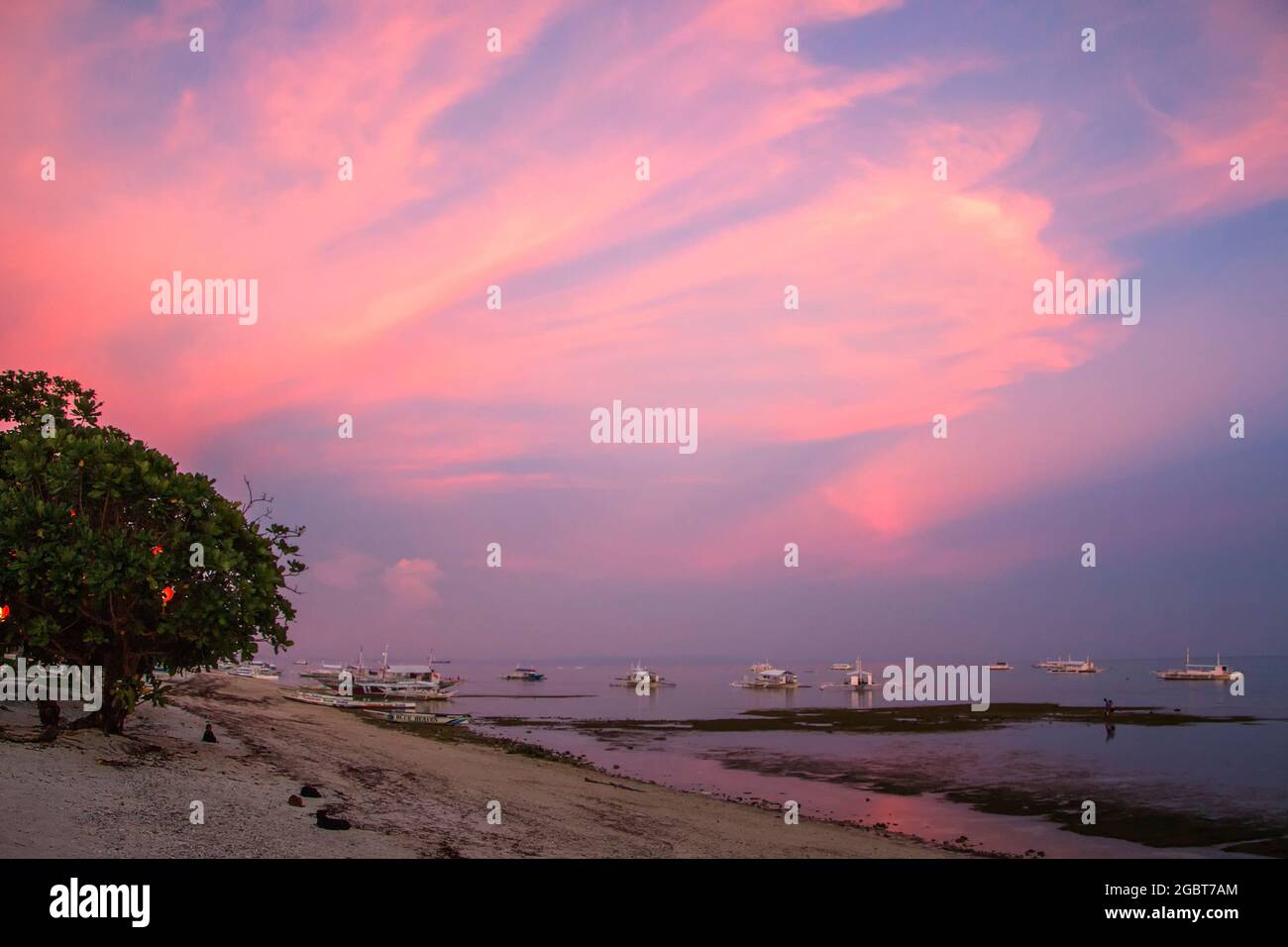 pink sunset and boats on beach Stock Photo - Alamy