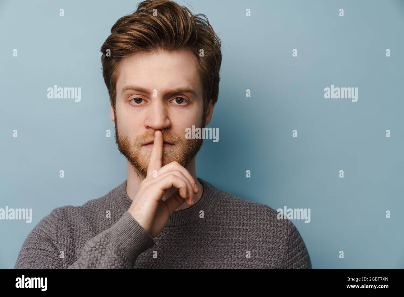 White ginger man with beard showing silence gesture at camera isolated ...