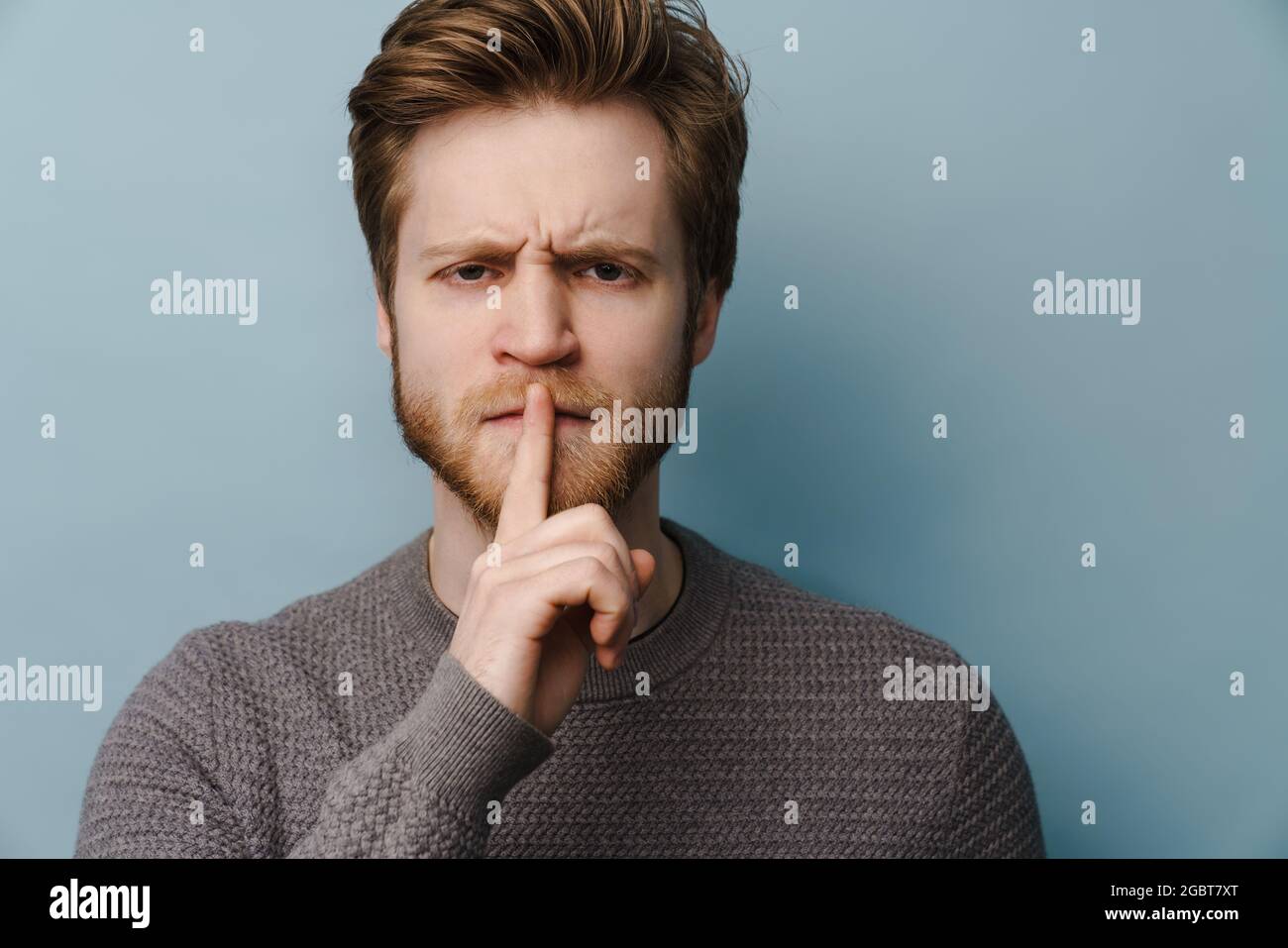 White ginger man with beard showing silence gesture at camera isolated ...