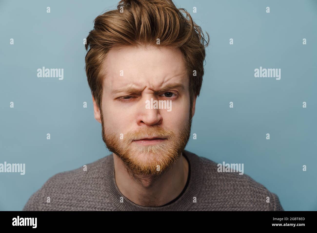 White ginger man with beard grimacing and looking at camera isolated ...