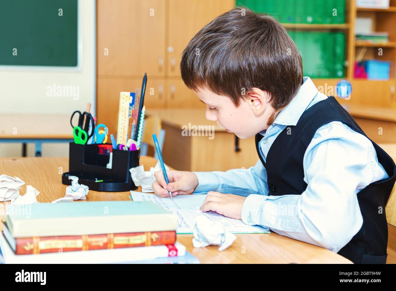 Serious schoolboy in the classroom. Primary school student. Back to ...