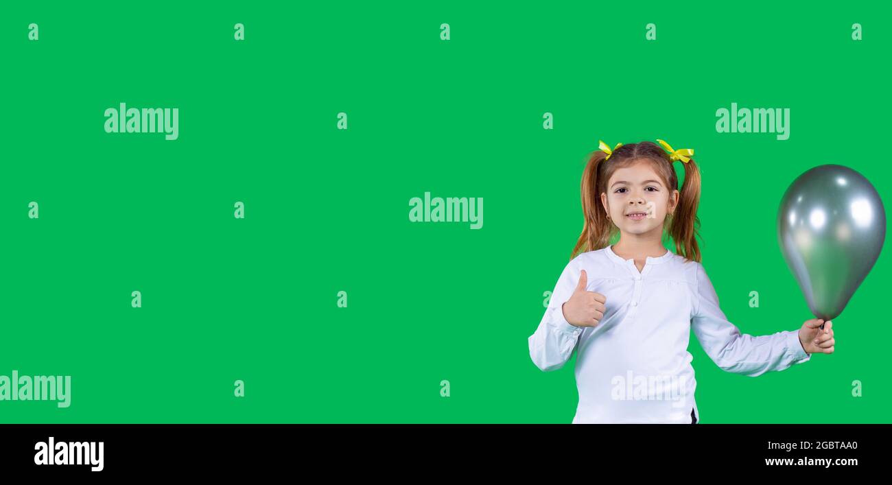 Good girl holds the brilliant green balloon in her hand and making ...