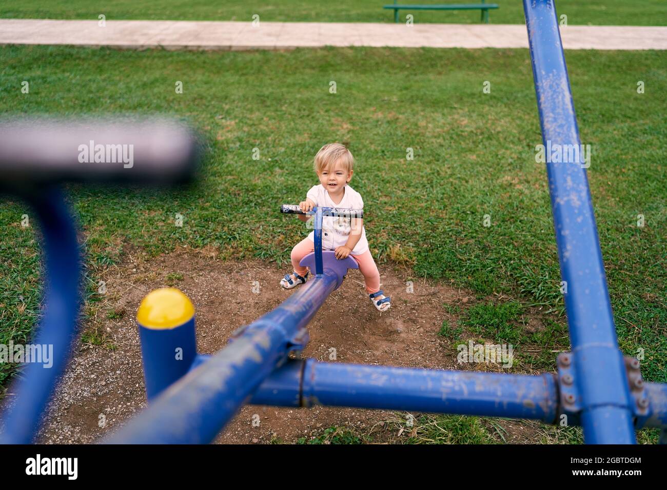 Little girl swinging on a balance swing in the playground Stock Photo ...