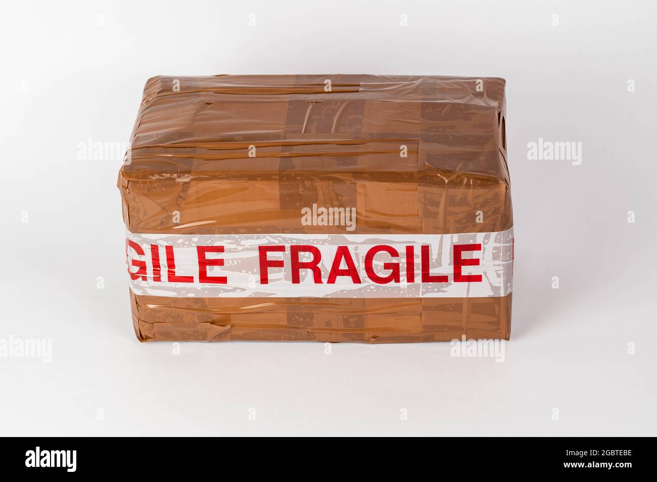 Parcel wrapped up with brown parcel tape and fragile written on in red ...