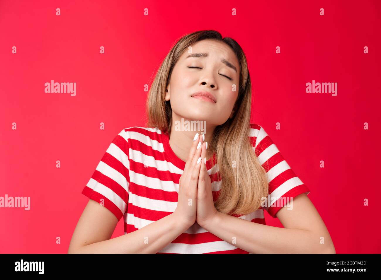 Close-up silly hopeful asian girl blond hairstyle, asking god help ...