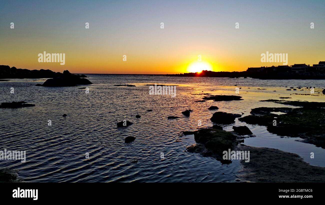 Beautiful sunset over the horizon of a clear ocean with small waves on ...
