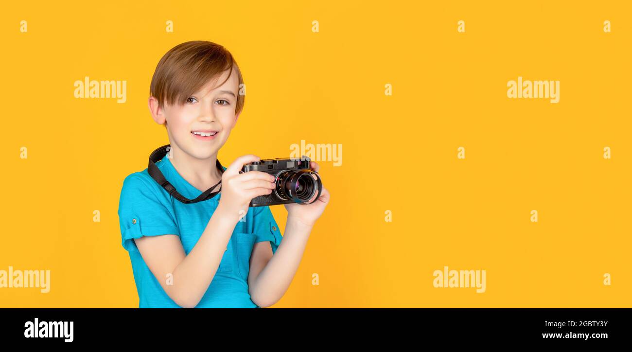 Little boy on a taking a photo using a vintage camera. Child in studio ...