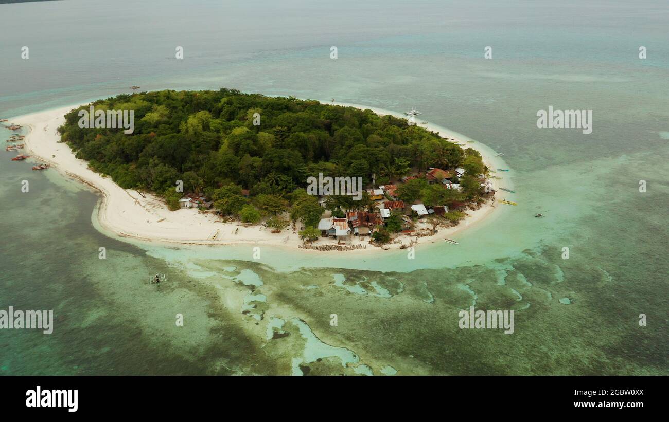 Small tropical island on an atoll with beautiful sandy beach surrounded ...