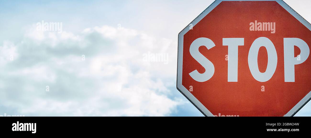 red stop sign with blue sky and clouds in background Stock Photo - Alamy
