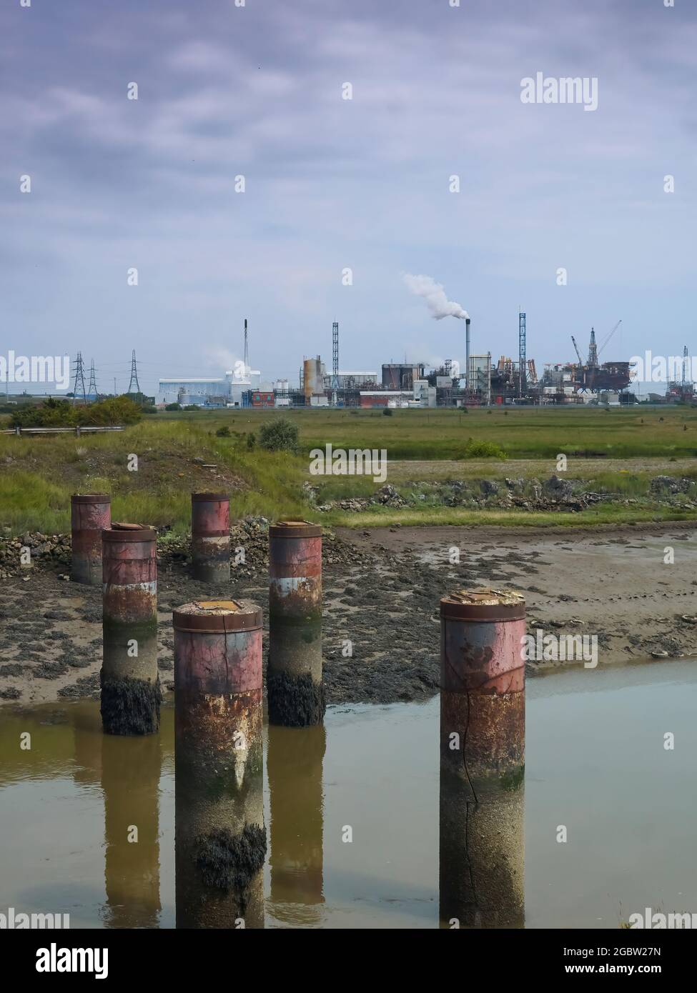 Derelict, deck-less bridge supports stand in a muddy creek and lead to ...