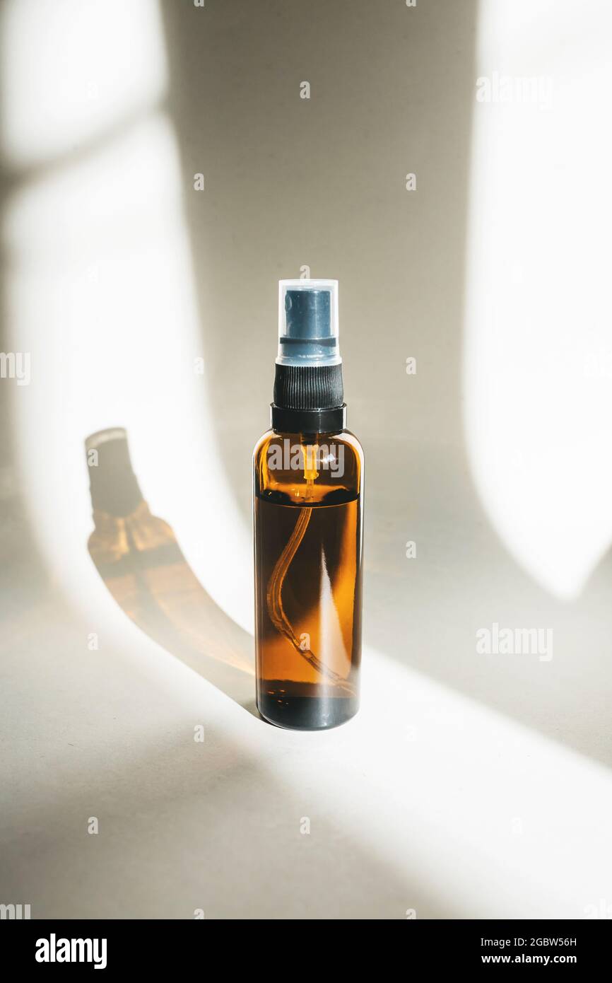 Cosmetic bottle made of dark amber glass on a white background with a ...