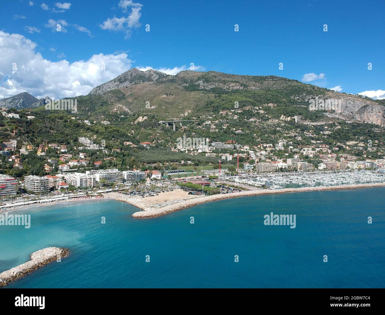 Aerial view of a beach with buildings and mountains in Menton, French ...