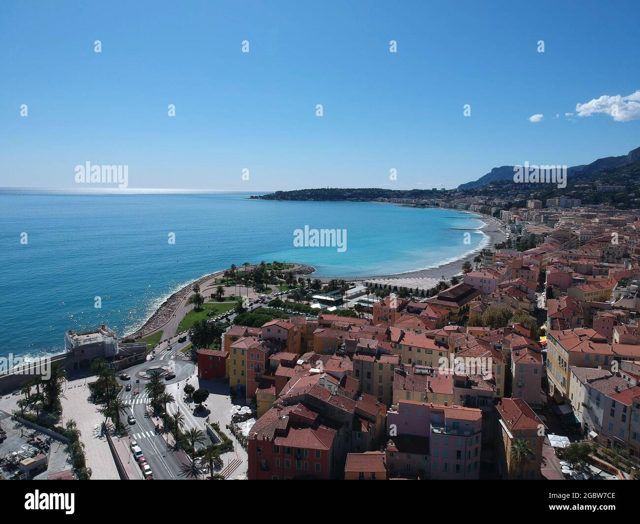 Aerial view of a beach with dense buildings under a clear sky in Menton ...