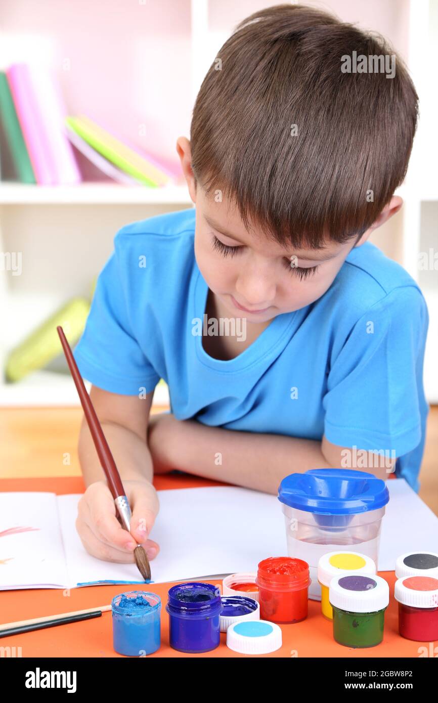 Cute little boy painting in his album Stock Photo - Alamy