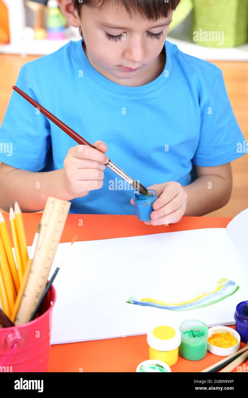 Cute little boy painting in his album Stock Photo - Alamy