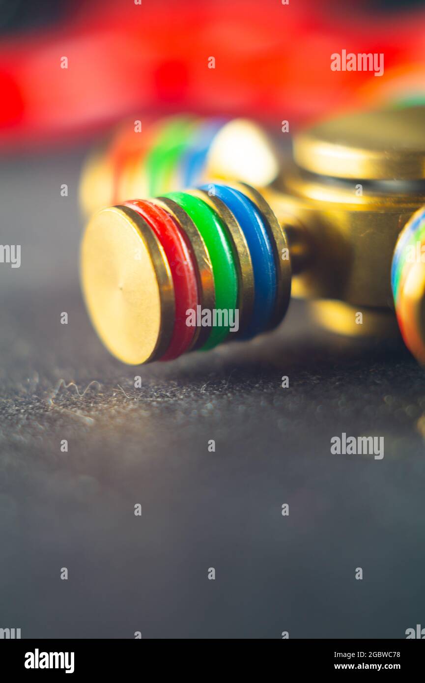 Vertical closeup of a metallic colorful spinner Stock Photo - Alamy