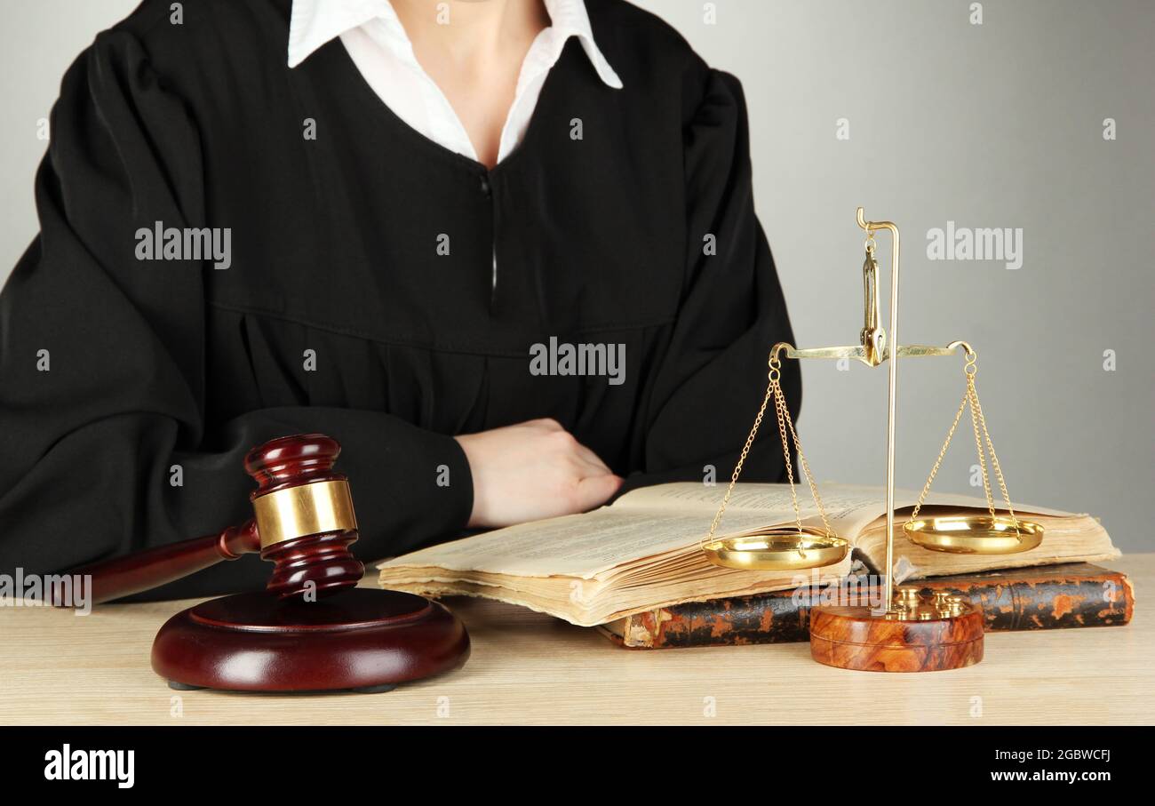 Judge sitting at table during court hearings on grey background Stock ...