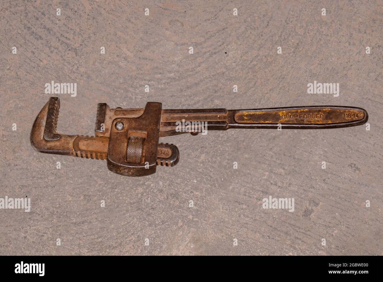 Old rusty metal pipe wrench tool on concrete floor Stock Photo - Alamy