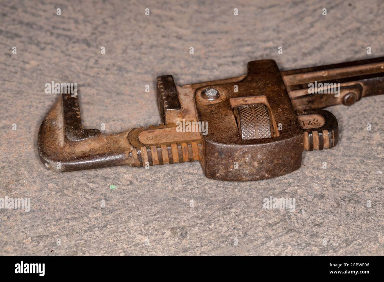 Old rusty metal pipe wrench tool on concrete floor Stock Photo - Alamy