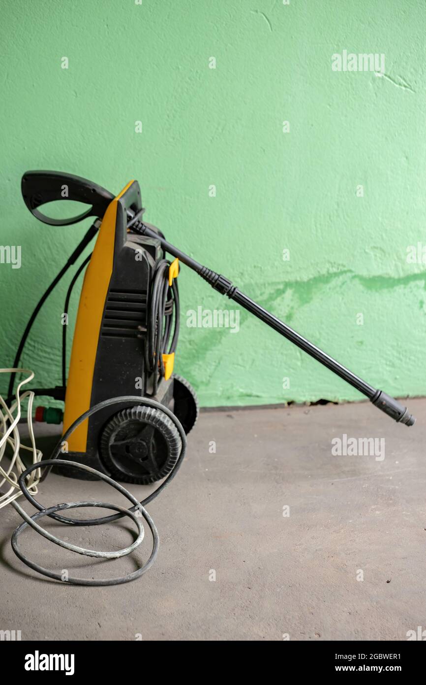 Yellow high pressure washer electric equipment with water Stock Photo ...