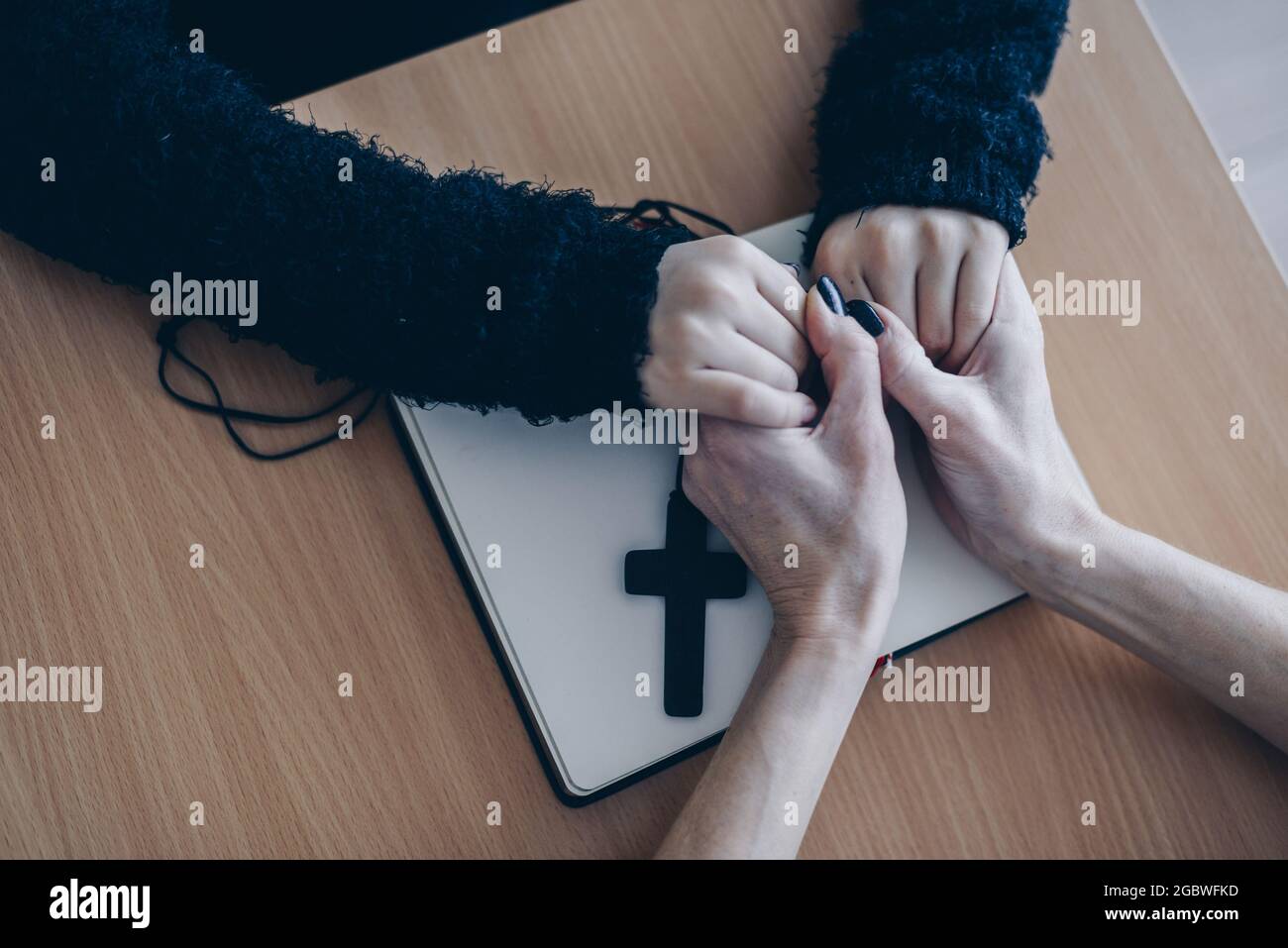 Two pairs of hands touch together to help each other. Together praying ...