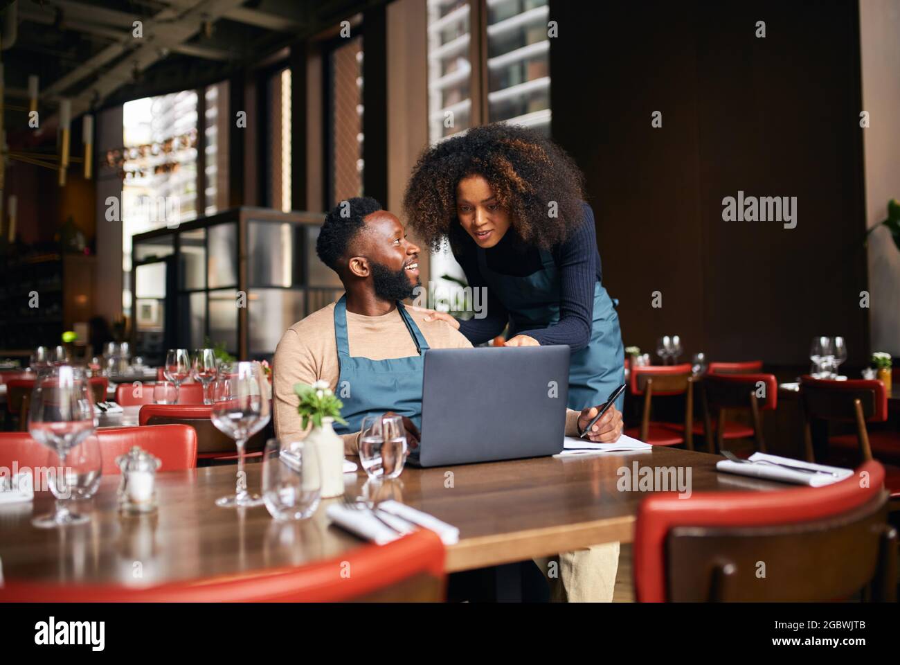 Restaurant owners working with laptop Stock Photo - Alamy