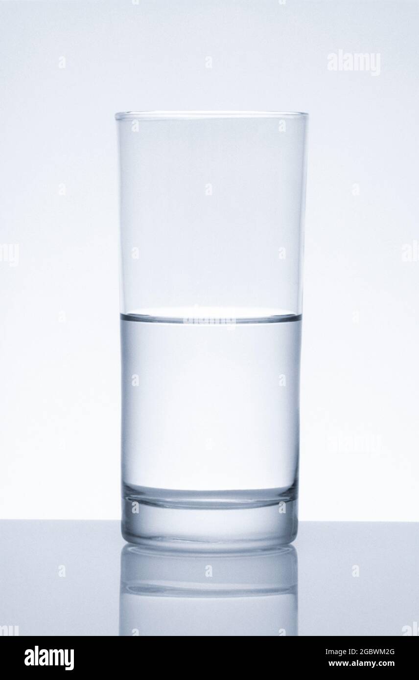 water glass with water against a white background, half full, half ...