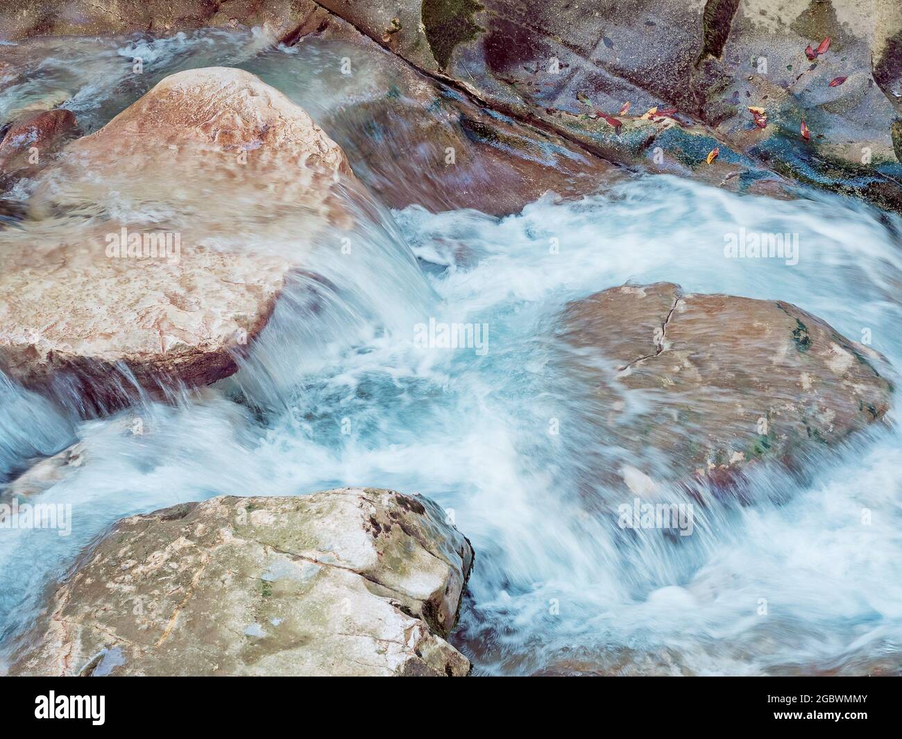 Bubbling foamy river flows over large rocks. Closeup photo Stock Photo ...