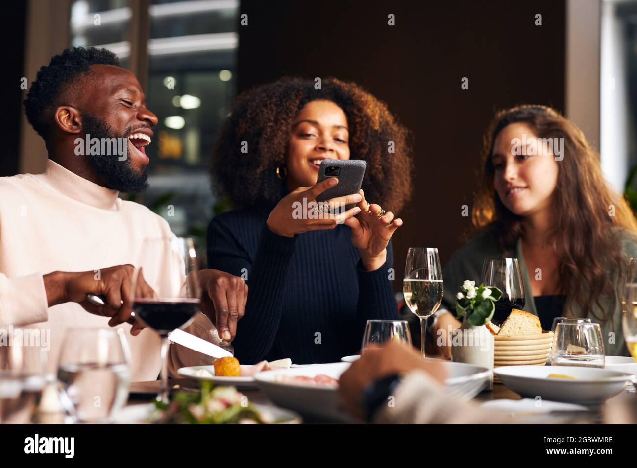 Friends photographing food in restaurant Stock Photo - Alamy