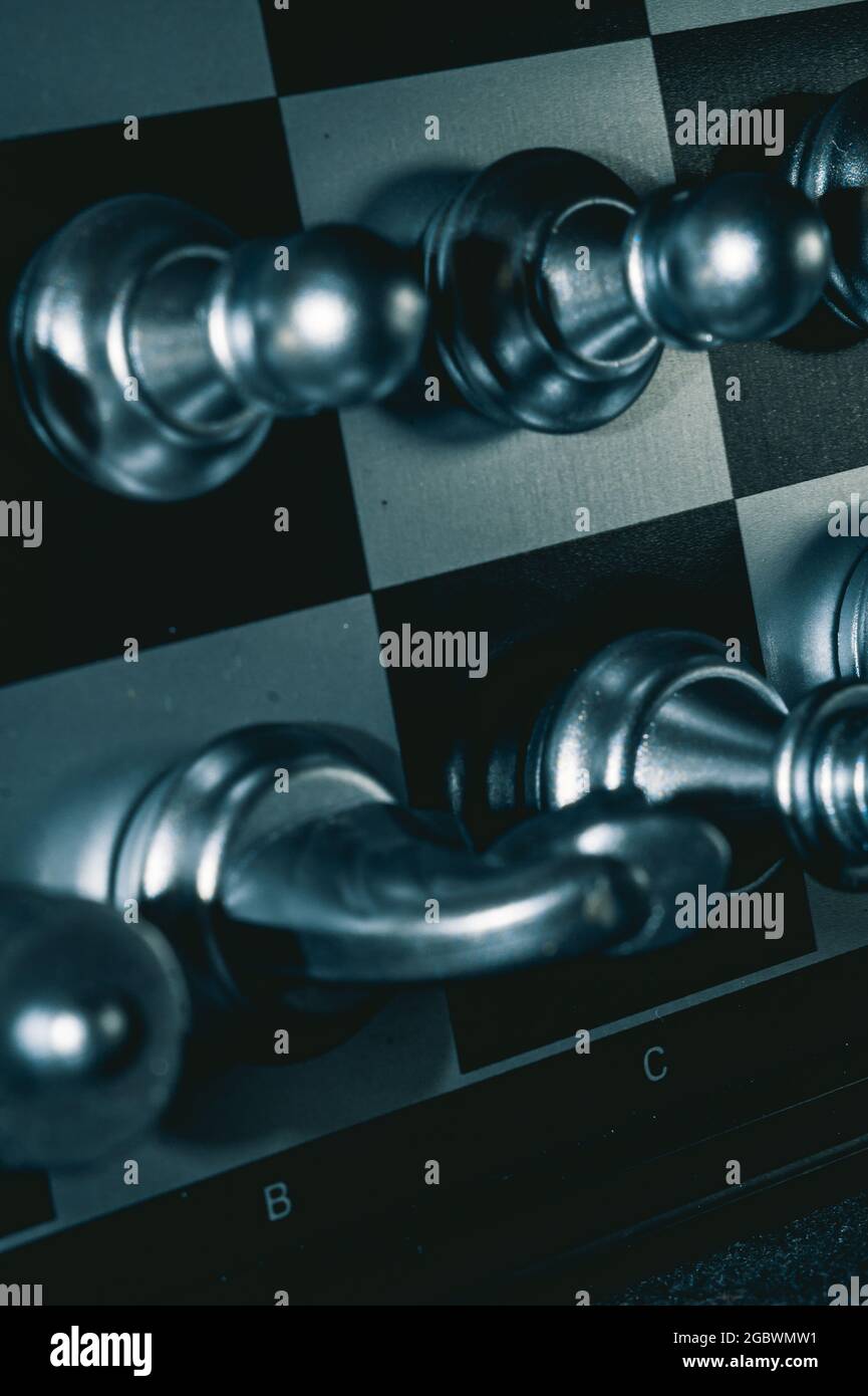 Vertical closeup shot of an arranged chess board with silver pieces ...