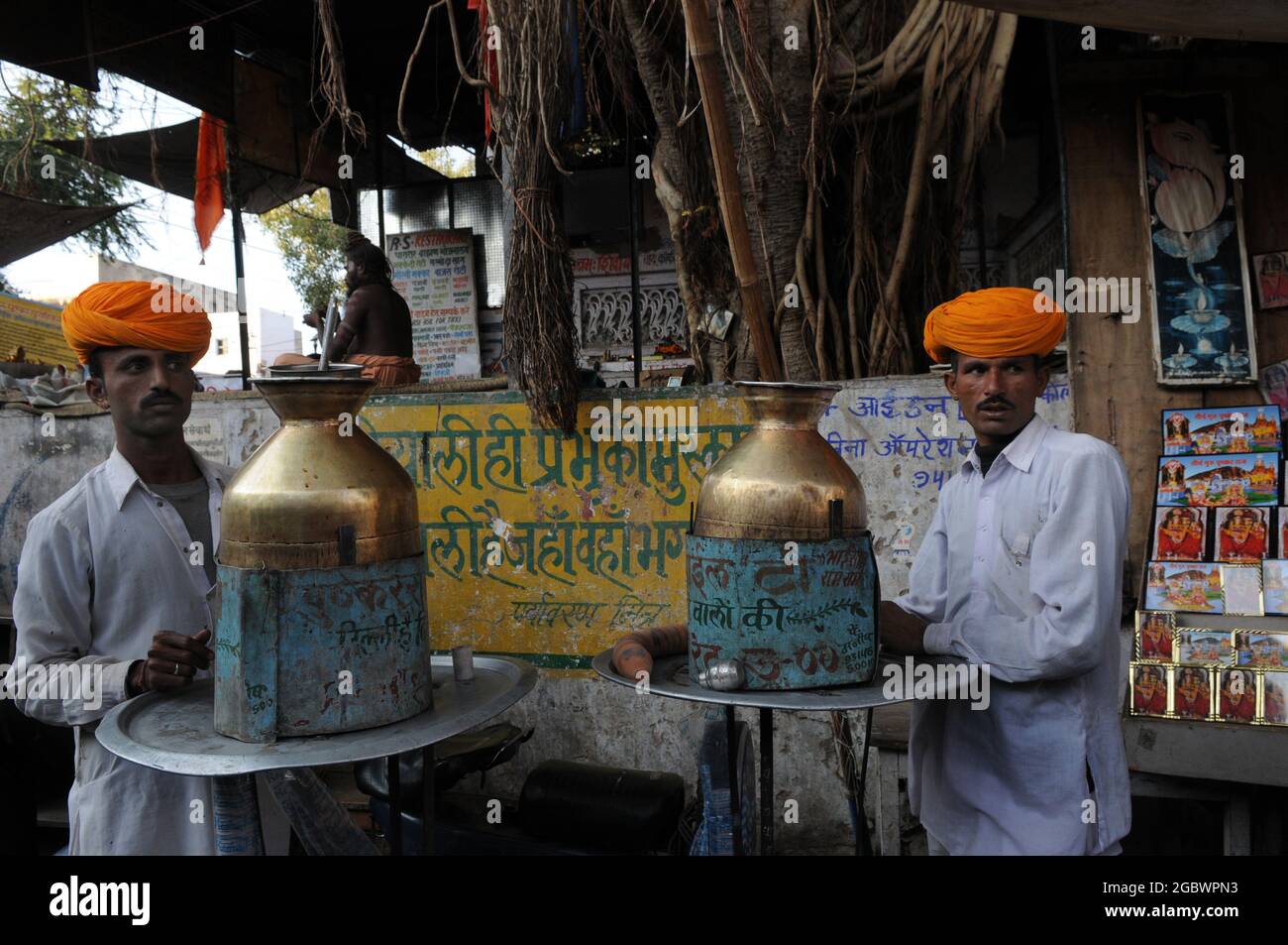 Traditional tea vendors with their brass container wait for customers ...