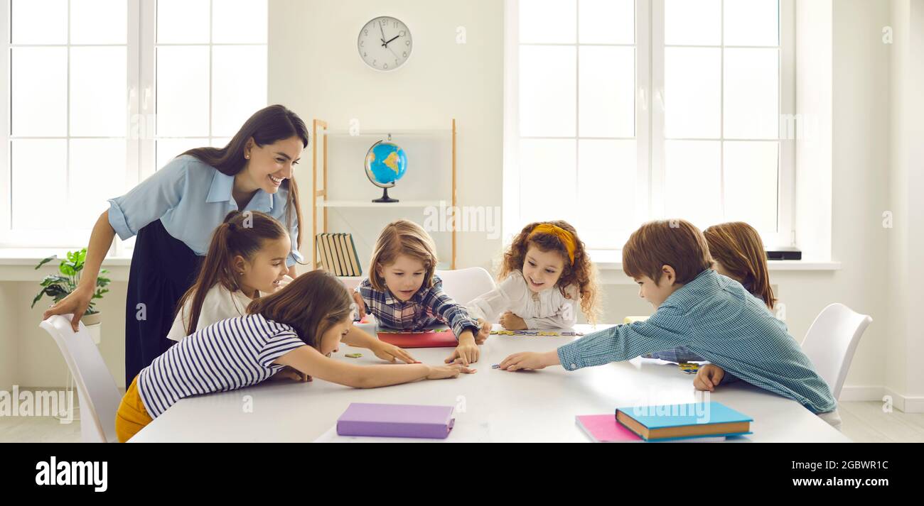 Female teacher and pupils group playing funny educational game in ...