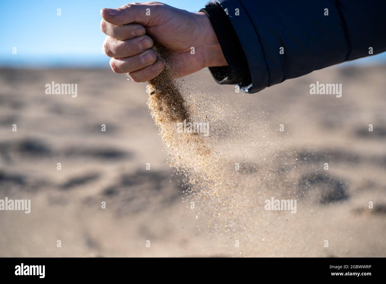 Male's hand pouring sand in a dune Stock Photo - Alamy