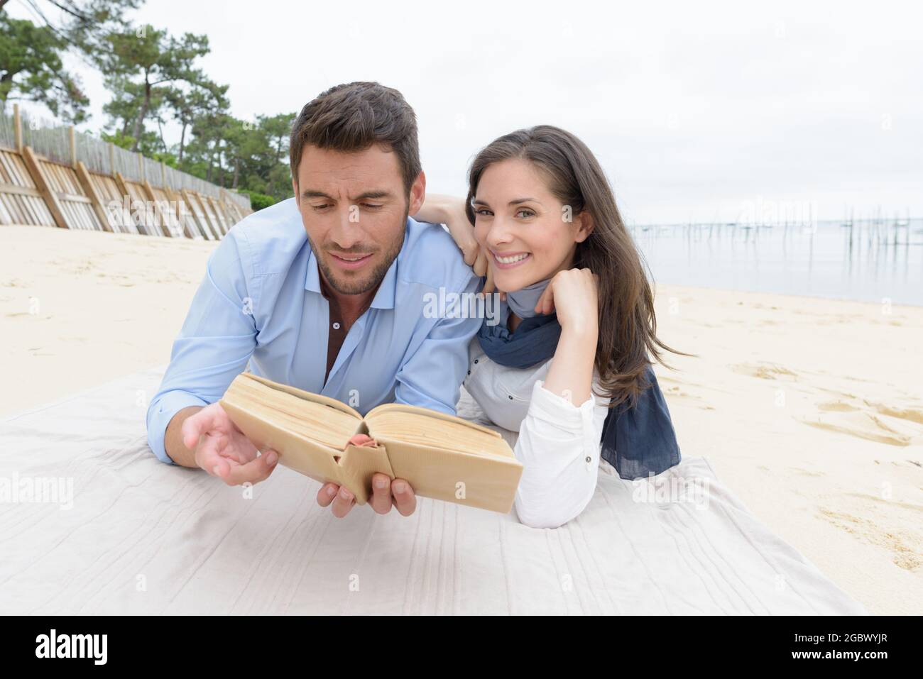 couple reading book on the beach Stock Photo - Alamy