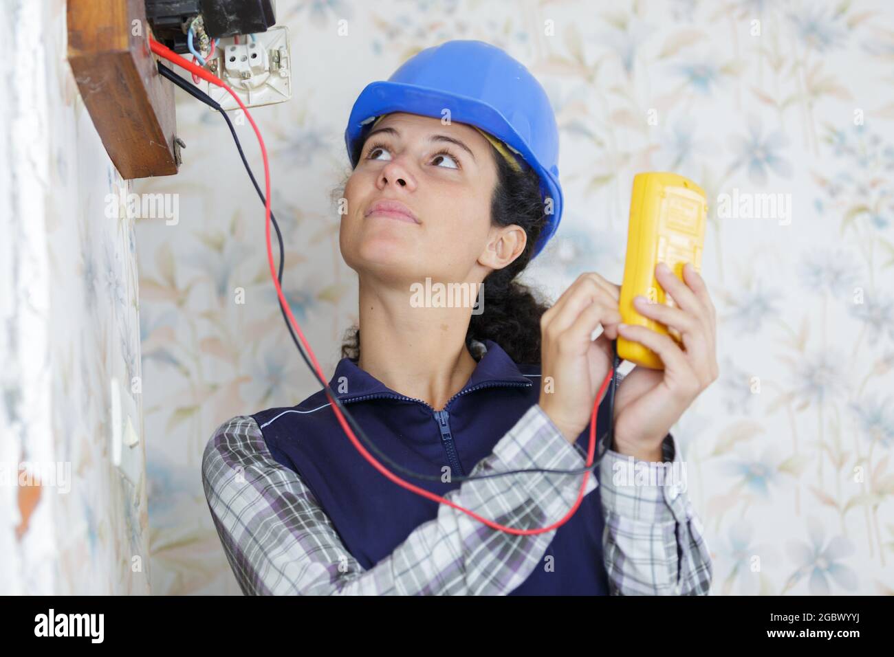 female electrician using multimeter on old electric meter Stock Photo ...