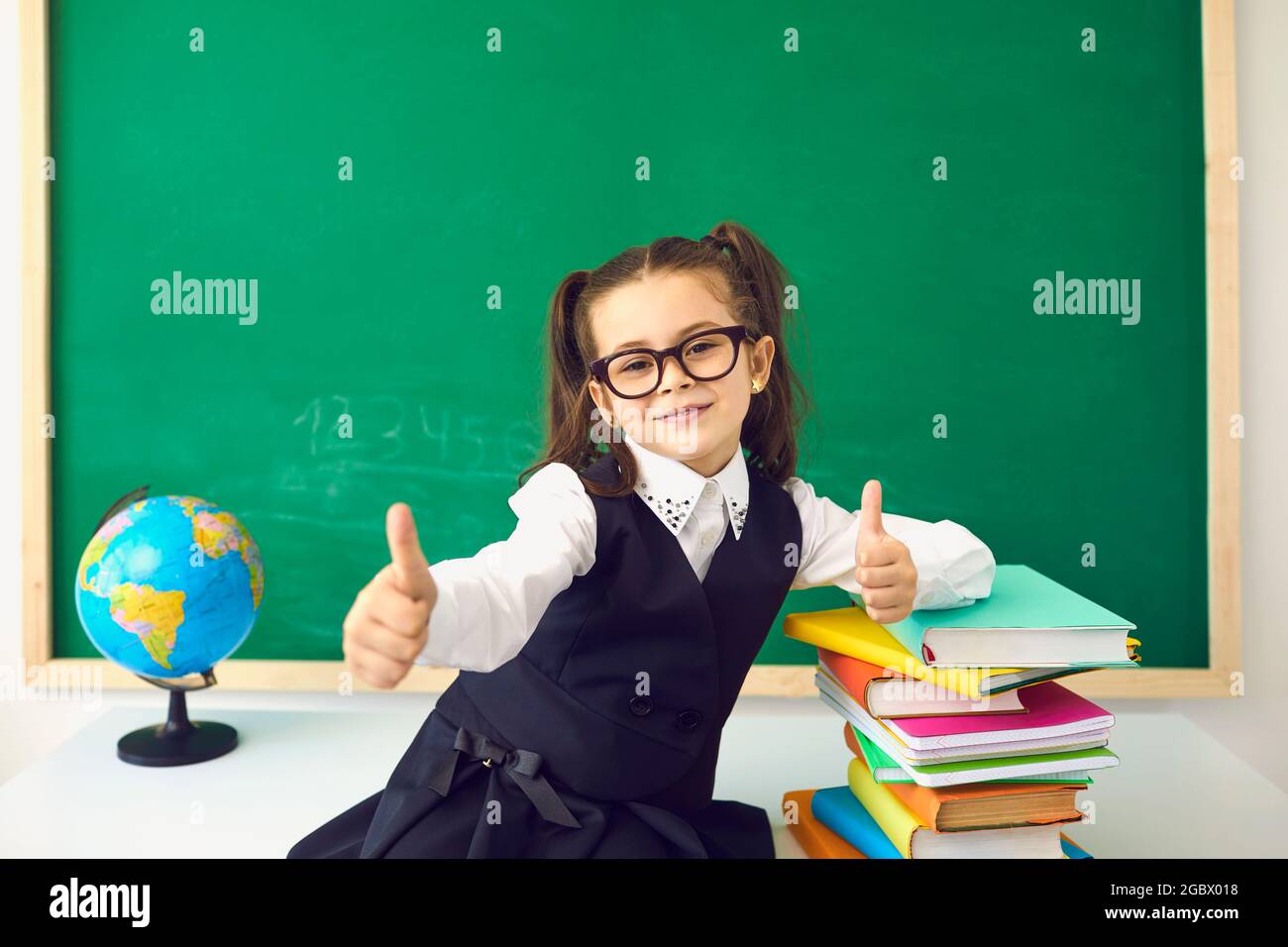 Back to school. The schoolgirl in glasses raised a thumb up while ...