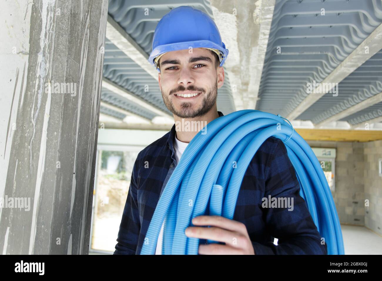 plumber with a reel of flexible blue pipe Stock Photo - Alamy