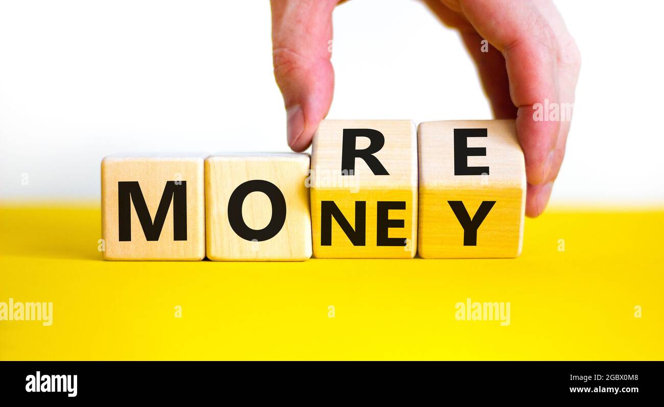 More money symbol. Businessman turns wooden cubes and changes the word ...