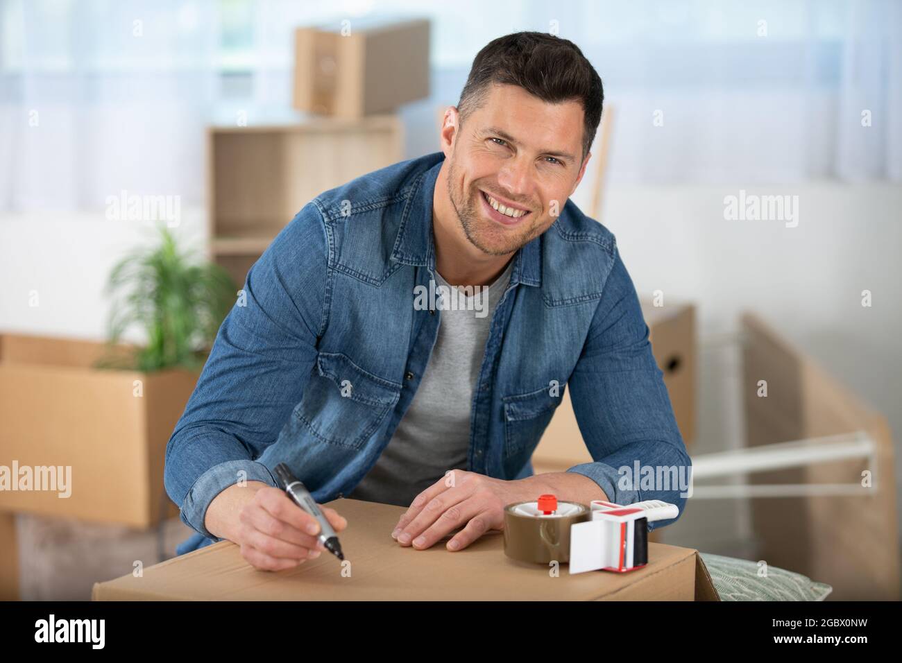 happy man writing on box Stock Photo - Alamy