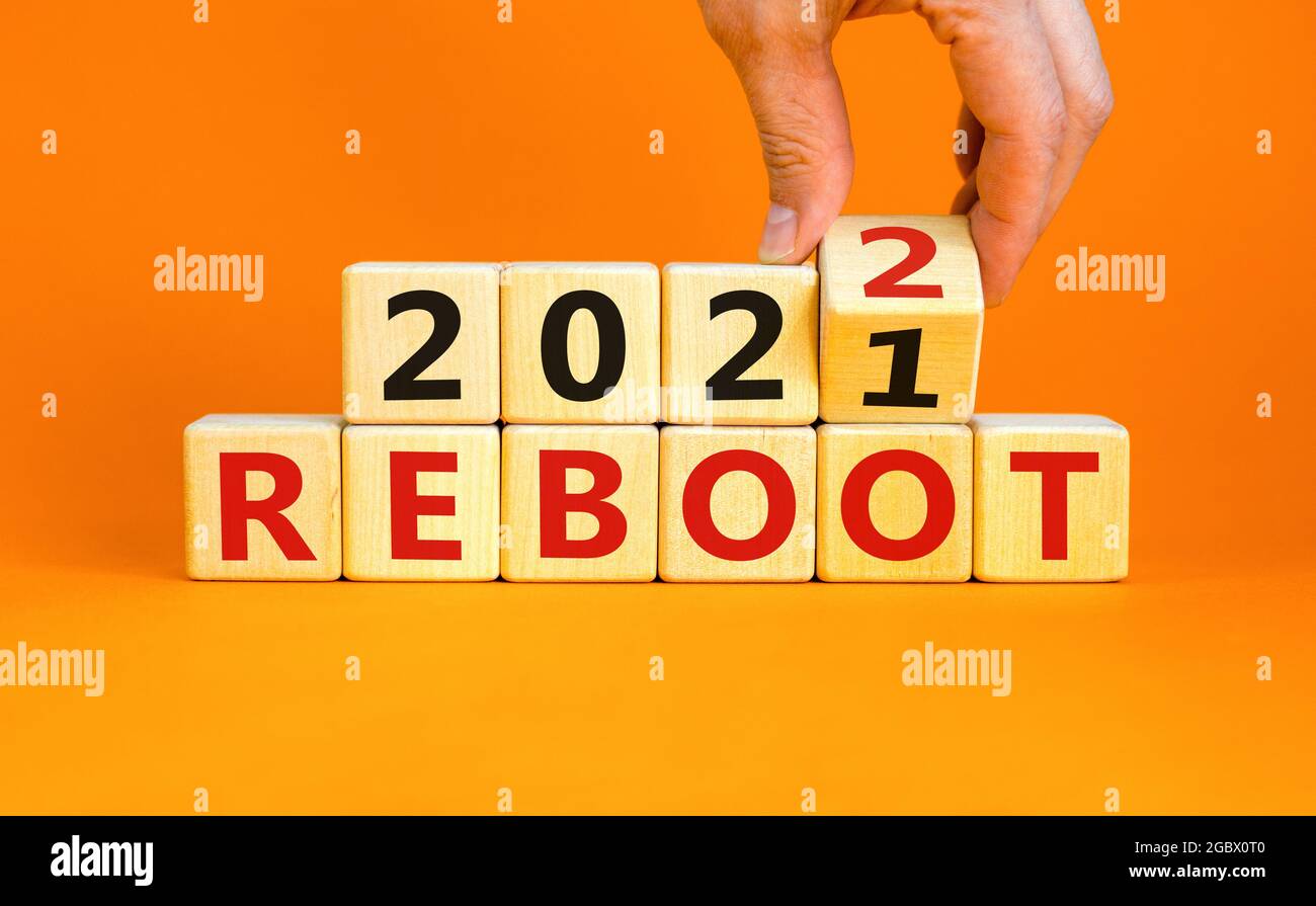 2022 reboot new year symbol. Businessman turns a wooden cube and ...