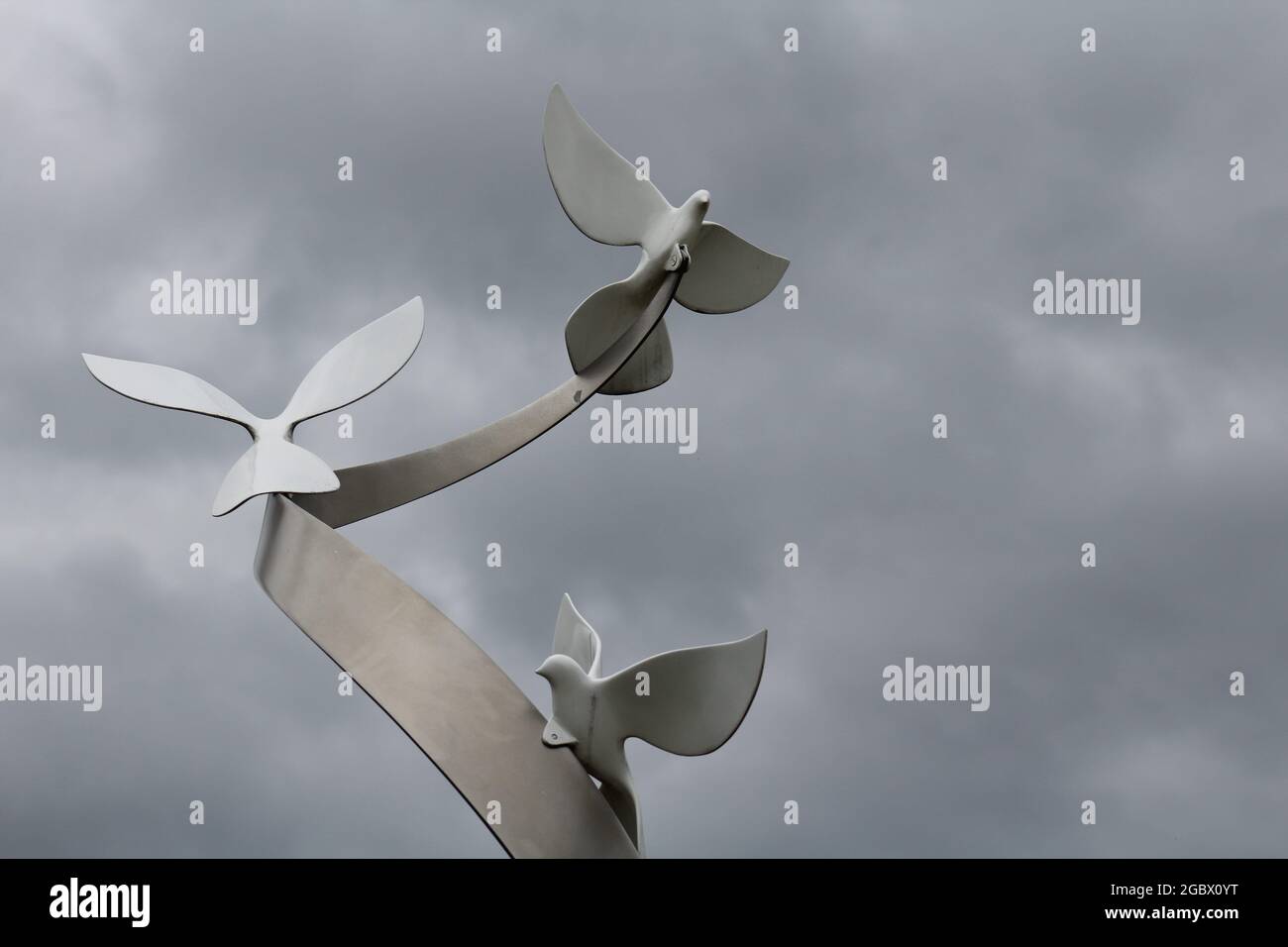 Dove Statue in front of a lot clouds Stock Photo - Alamy