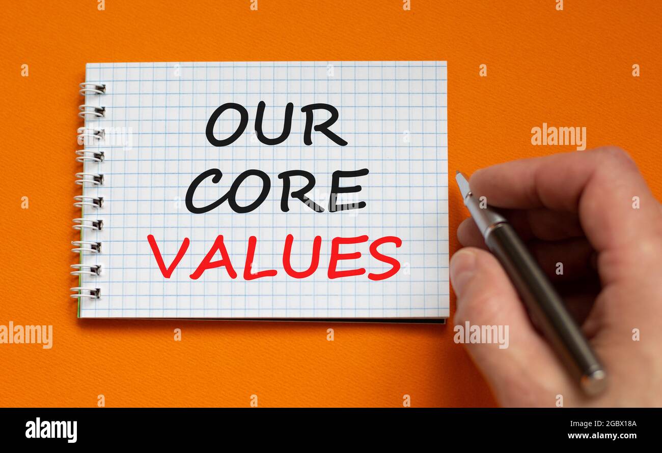 Our core values symbol. Businessman writing words 'Our core values' on ...