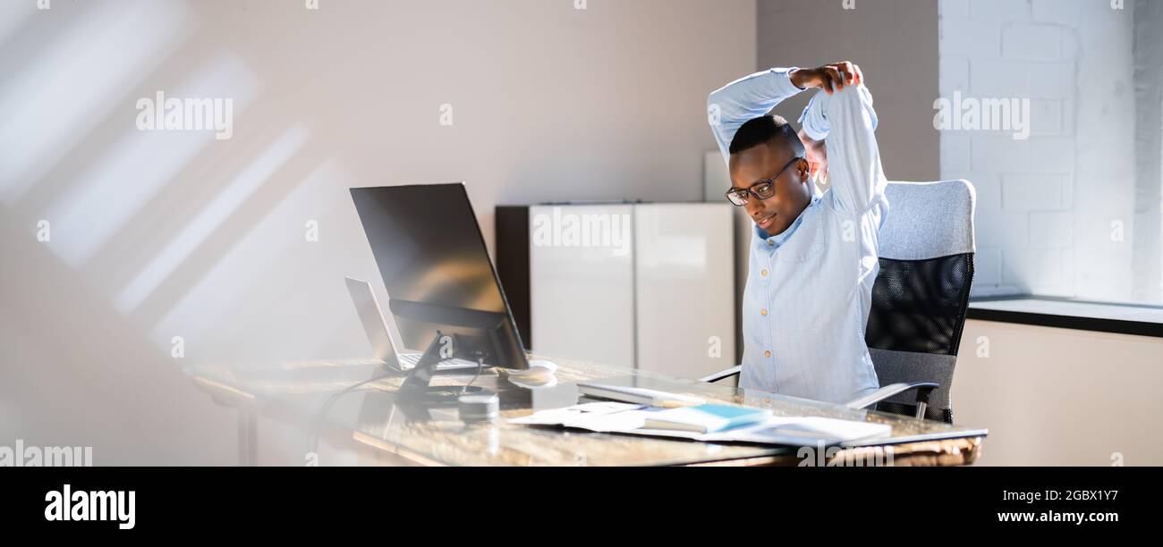 Arms Stretch Exercise Sitting At Desk In Office Stock Photo - Alamy