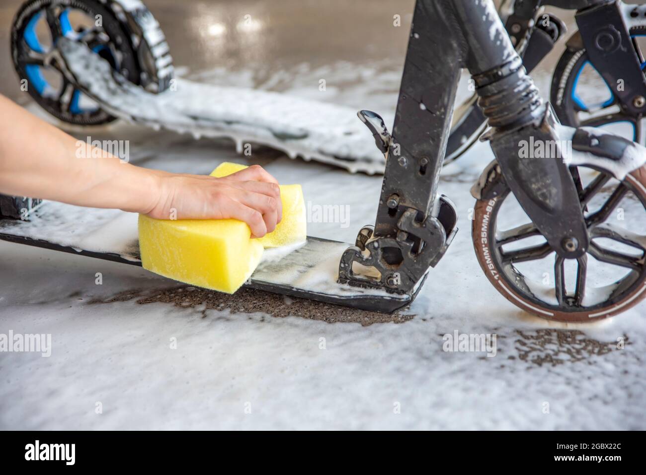 Cleaning scooter. Electric scooter care. A woman's hand washes a ...