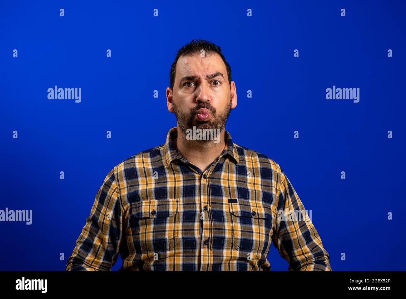 Photo of attractive young unshaven man with innocent expression, looks ...