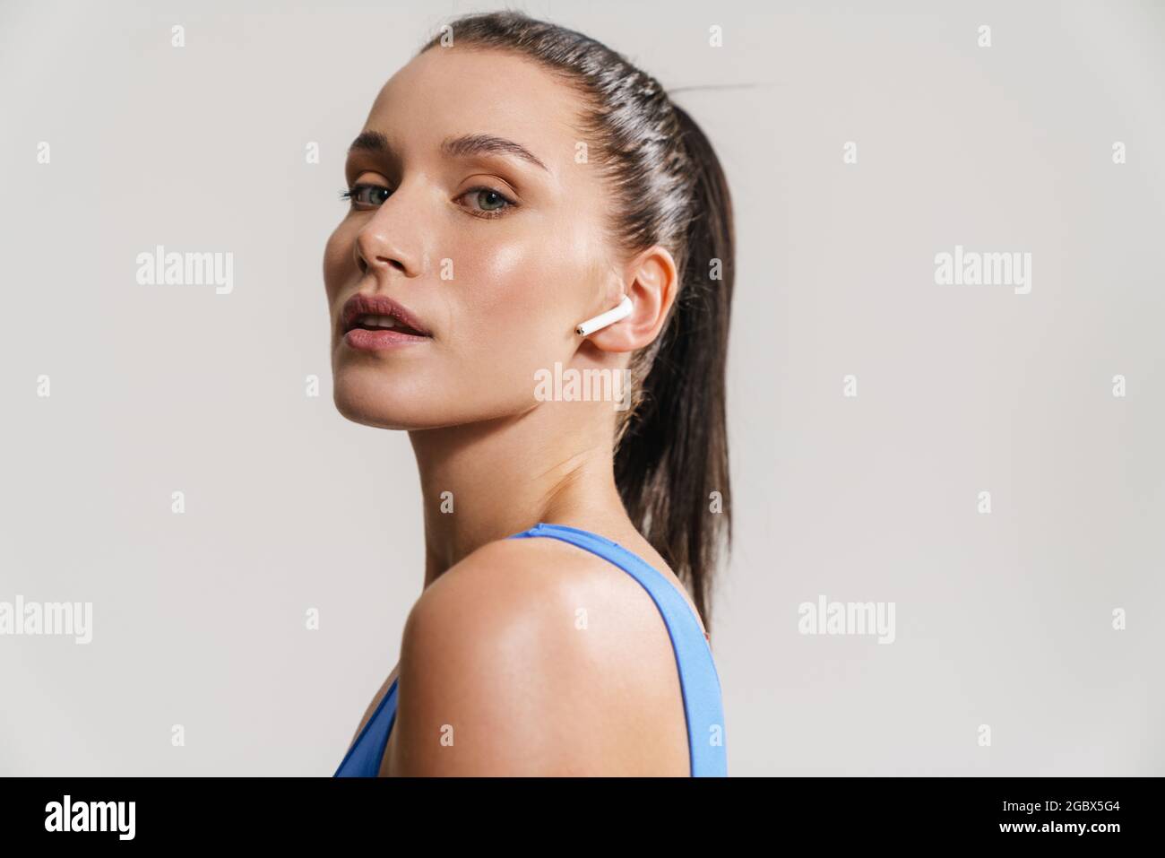 Young white fitness woman in sportswear with ponytail standing over ...