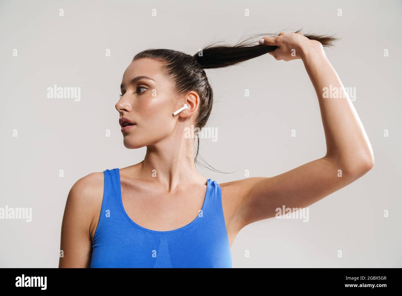 Young white fitness woman in sportswear with ponytail standing over ...