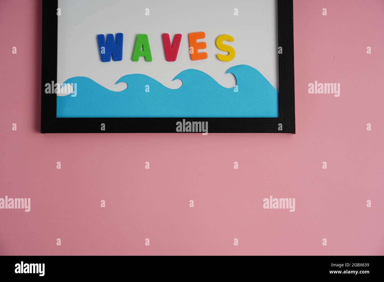 Word waves written in colored alphabets on a frame with a pink ...