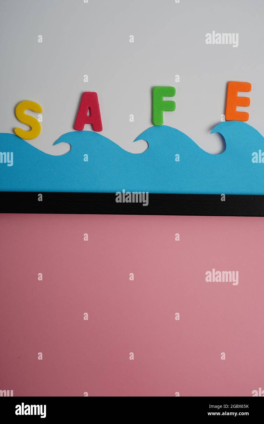 Word safe written in colored alphabets on a frame with a pink ...
