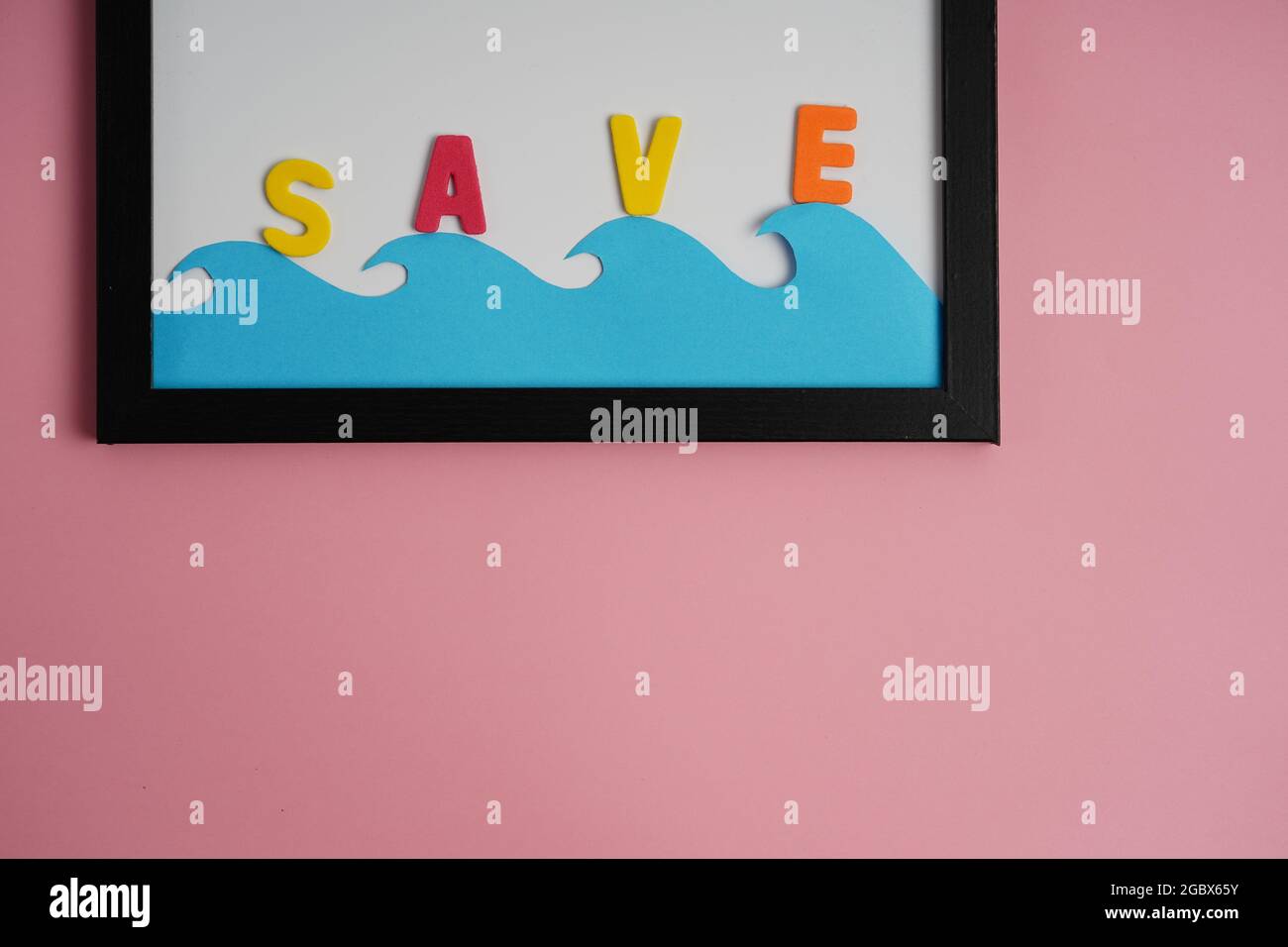 Word save written in colored alphabets on a frame with a pink ...